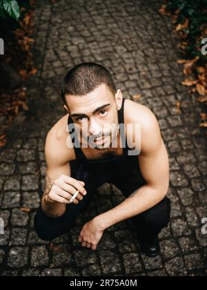 man, short hair, cigarette, squat, from above Stock Photo - Alamy