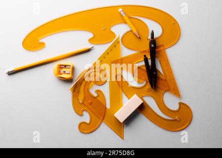 Close up of yellow rulers, compass and sharpener on white background ...