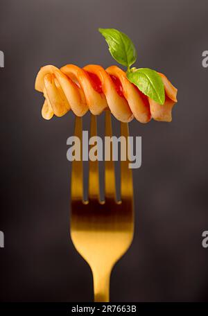 Macro food photography of giant fusilli, pasta, basil, pesto, sauce ...