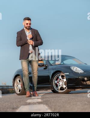 A handsome elegant male next to his sports car Stock Photo - Alamy
