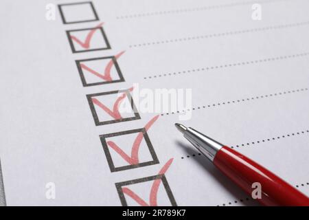 Paper sheet with checkboxes and pen on light grey table, closeup ...