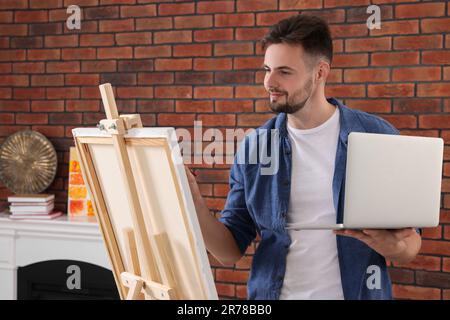 Man learning to draw with online course on laptop at home. Time for ...