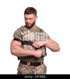 Soldier in military uniform applying medical tourniquet on arm against ...