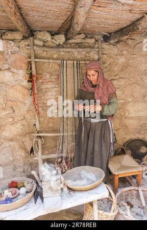 An actress portrays a first century woman preparing a meal at the ...