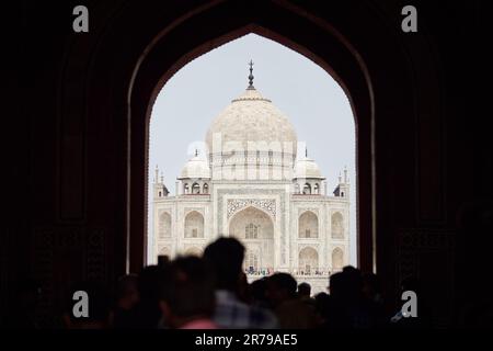 Archway of main gateway in Taj Mahal entrance with tourists silhouettes ...