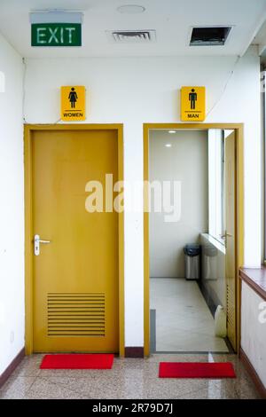 Yellow-colored restroom markers distinguishing men's and women's ...