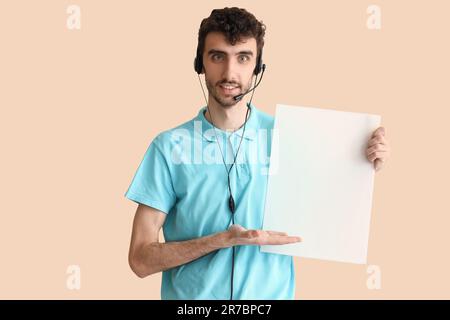 Male technical support agent with blank poster on lilac background ...
