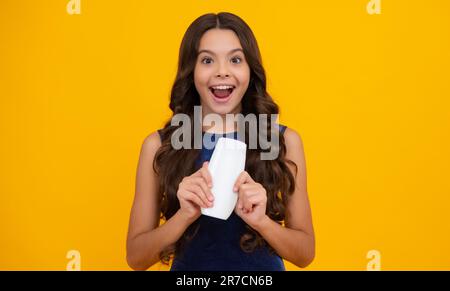 Teenager child girl showing bottle shampoo conditioners or shower gel ...