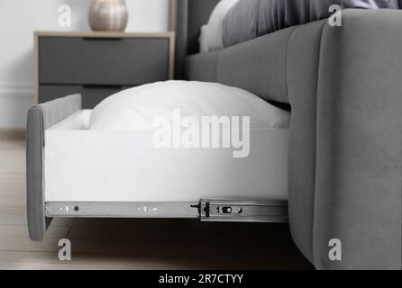 Storage drawer with white pillow under modern bed in room Stock Photo ...