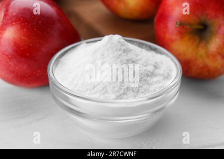 Sweet powdered fructose and fresh apples on light blue background Stock ...