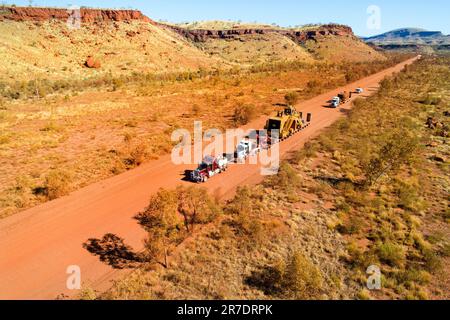 Aerial view of a 994K large wheel loader being transported on red dirt ...