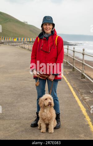 Blonde cockapoo dressed in a blue fleece dog suit with built-in legs ...
