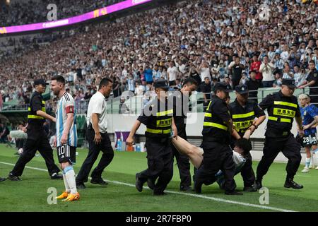 Security guards remove a pitch invader as Argentina's Lionel Messi ...