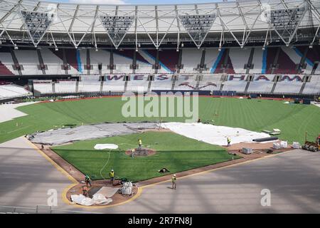 Workers transform the pitch into a baseball field at the London Stadium ...