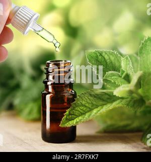 Brown bottle with dropper and drop of scented oil falling, with orange ...