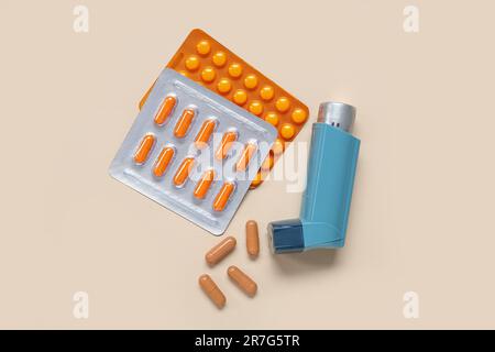 Asthma inhaler and pills on beige background Stock Photo - Alamy