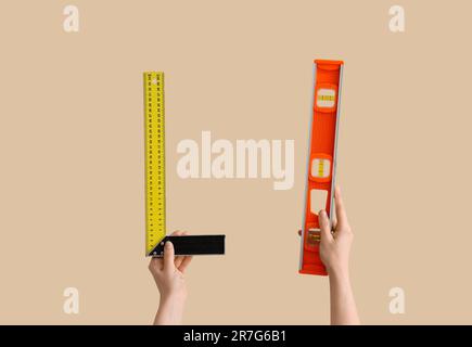 Female hands holding builder's level on beige background Stock Photo ...