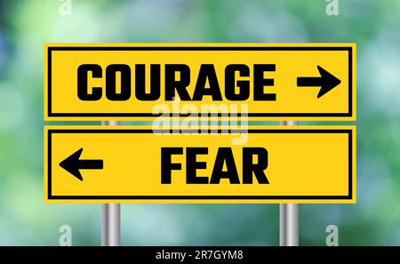 Courage road sign on blur background Stock Photo - Alamy