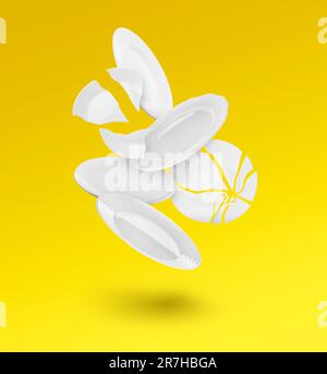 Whole and broken plates falling on white background Stock Photo - Alamy