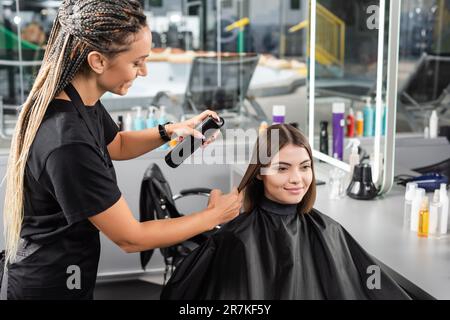 salon services, hair spray, happy hairdresser with braids styling hair ...
