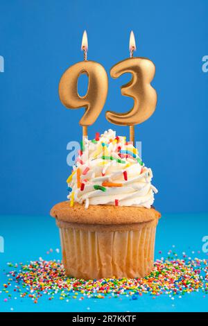 Number 93 blue celebration candle and gold confetti on dark wooden ...