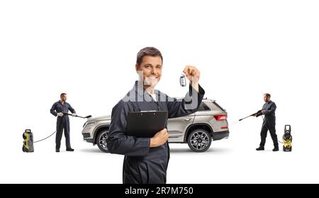 Workers in uniforms washing a SUV with a pressure washer machines ...