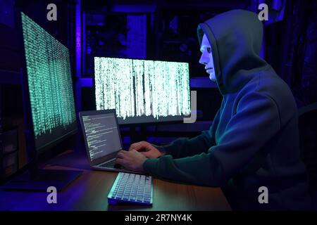 Hacker in mask working with computers in dark room. Cyber attack Stock ...
