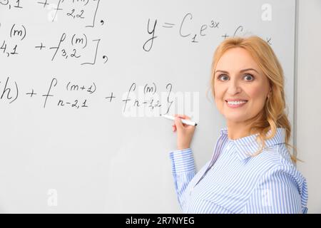 Professor writing down math equation on whiteboard Stock Photo - Alamy