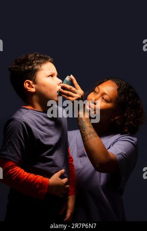 Healthcare professional assisting 7 year old boy using inhaler Stock ...