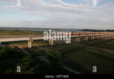 An Indian passenger train passes over a bridge on river Ganges in ...
