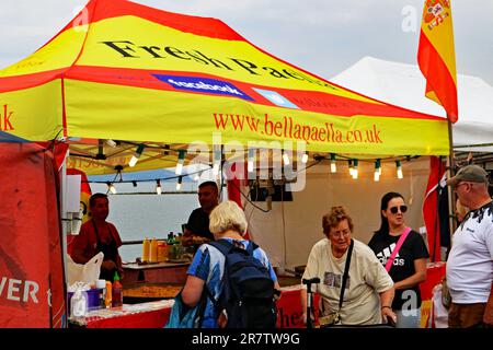 Colourful crowds and stalls at a pop-up street market and food festival ...