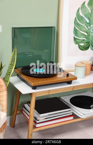 Stylish turntable with vinyl record console table in room Stock Photo ...
