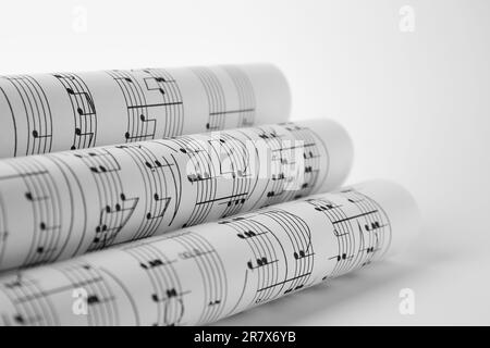 Rolled sheets with music notes on white background, closeup Stock Photo ...