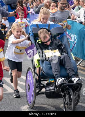 Rob Burrow is pushed by his daughters, Maya (left), 8, and Macy (right ...