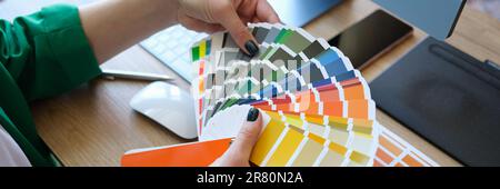 Designer shows color palette of samples of different colors and shades ...