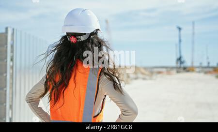 Hispanic young woman wearing architect hardhat at office smiling happy ...
