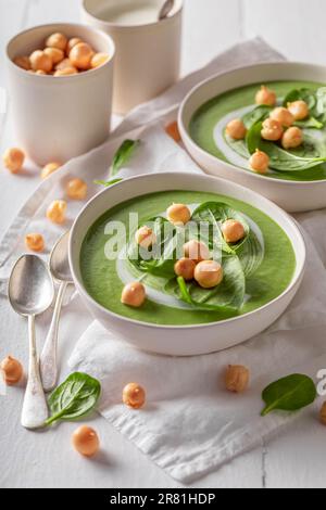 Vegan spinach soup with peas puff, leaves and cream. Vegan soup made of ...