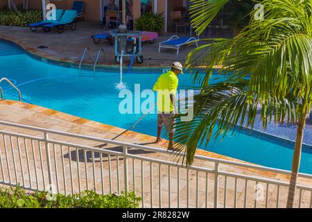 View of hotel's employee cleaning outdoor pool. Aruba. Oranjestad Stock ...