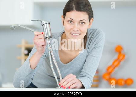 a lady fitting kitchen tap Stock Photo - Alamy