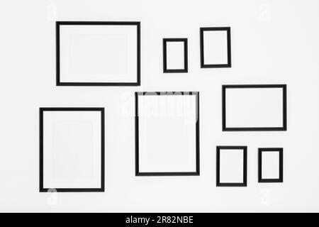 Empty frames hanging on white wall and chest of drawers indoors Stock ...
