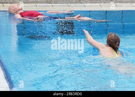 Lifeguard rescuing woman from swimming pool Stock Photo - Alamy