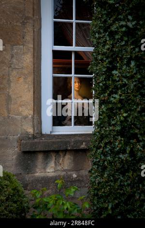 Paintings peer out through the window of a Fine Art Gallery in Broadway ...