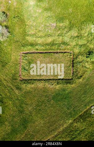 Aerial shot of unfinished house foundation in grass field from drone ...