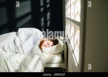 Young insane man with psychosis in straitjacket shouting while lying on ...