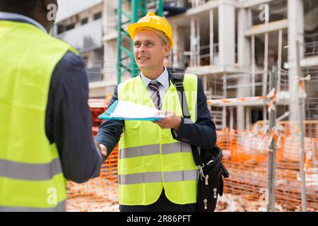 Two confident civil engineers exchange a friendly handshake Stock Photo ...