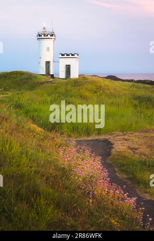 Scenic seascape landscape at dusk of Elie Ness Lighthouse on the East Neuk Peninsula in coastal ...