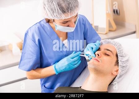 Man getting face injections at aesthetic clinic Stock Photo - Alamy