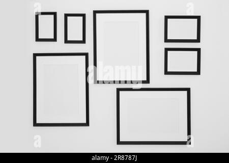 Empty frames hanging on white wall indoors Stock Photo - Alamy