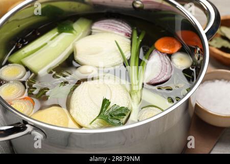 Different ingredients for cooking tasty bouillon in pot on black table ...