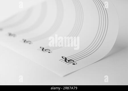 Sheet with empty staves for music notes and treble clef as background ...
